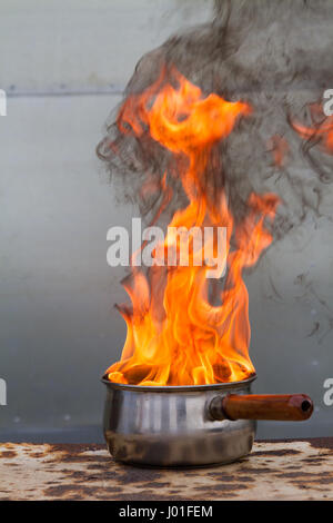 Vertikale Aufnahme einer Kochtopf auf Feuer mit riesigen Firery Flammen ...