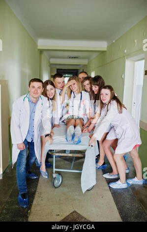 Lustige Ärzte posiert auf dem Bett für kranke Patienten im Krankenhaus ...