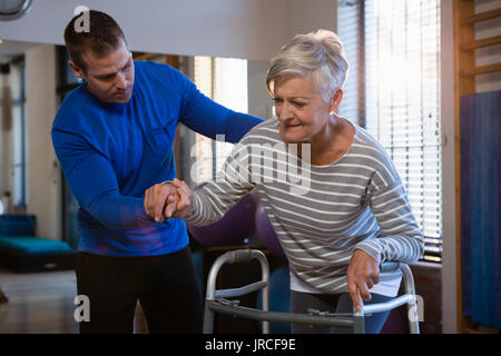 Physiotherapeuten helfen Patienten mit Gehhilfe in der Klinik zu gehen ...