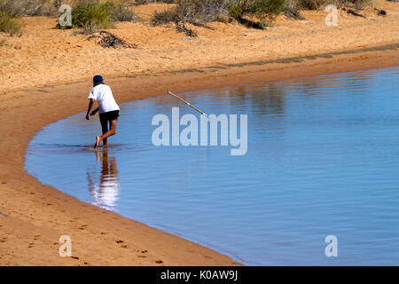 Junge Aborigines mann Speerwerfen in Wasser, Versuch, um Fische zu ...