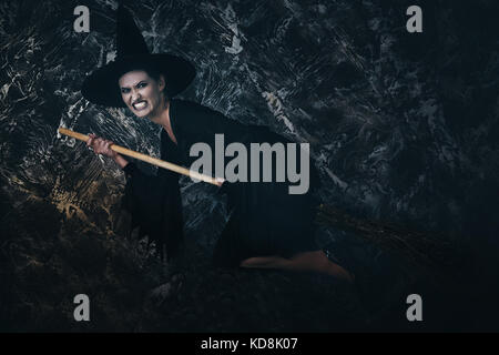 Beängstigend fliegende Hexe auf Besen, Dekoration hängen in einem Baum ...