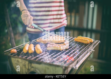 Freunde Grill und dem Mittagessen in der Natur. Paar Spaß beim Essen ...