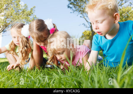 Niedliche Kinder mit Lupe im Freien. Spielende Kinder im Wald mit Lupe Stockfotografie - Alamy