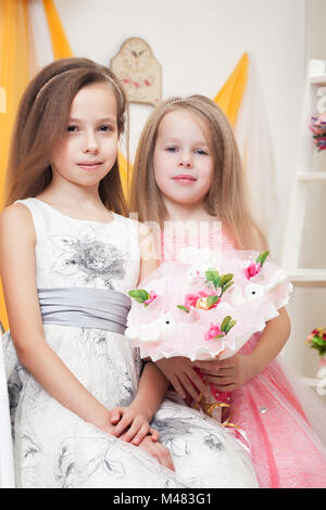 Hübsche kleine Zwillingsschwestern posieren. Eine zeigt die andere Seite nach vorne ...