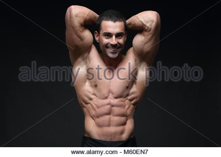 Schöne muskulöse Sportler mit Hände hinter Rücken Blick in die Kamera ...