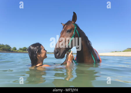 Reiterin/weibliche Reiterin Baden/Paddeln mit Pferd im seichten Wasser ...