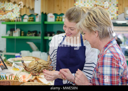 Weibliche Fischhändler frische Muscheln am Schalter im Mercado De La ...