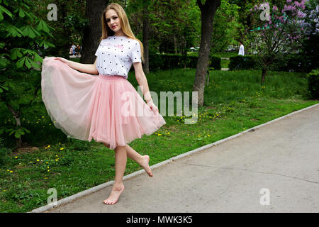 Schöne blonde Mädchen barfuß auf Sommerwiese mit einem Bouquet von ...