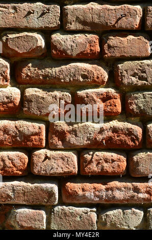 Sehr altes Mauerwerk aus rotem Backstein. Wand mit Gips abgefallen ...
