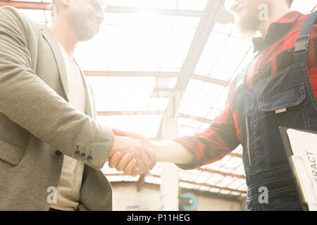 Kunden, die das Händeschütteln mit Mechaniker Stockfotografie - Alamy