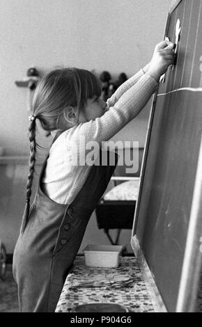 Berlin, DDR, Mädchen sitzt in der Vorschule zahlen von Papier auf einer ...