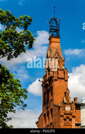 Alte Backsteinhäuser mit Türmen und roten Rollläden unter blauem Himmel ...