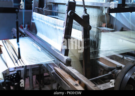 Vietnamesische Frau betreibt eine seidenweberei Maschine in der ...