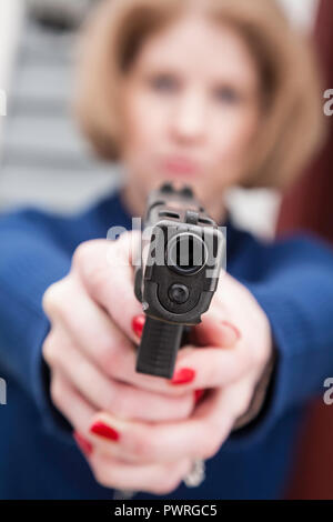 Frau mit Pistole auf den Kopf Stockfoto, Bild: 140699021 - Alamy