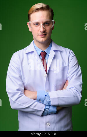 Junge blonde Mann trägt Arzt Uniform und Stethoskop in der Klinik ...