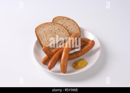 Frankfurter Würstchen mit Senf und einer Scheibe Brot Stockfoto, Bild ...