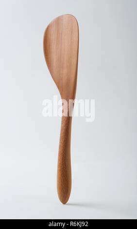 Handgefertigte Holzspachtel senkrecht auf einem weißen Hintergrund ...