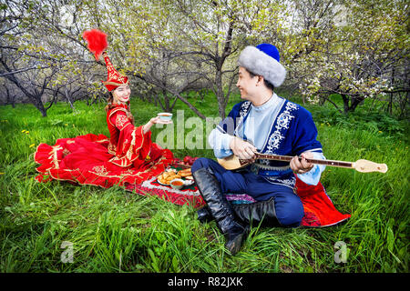 Spielen Dombura Mann und Frau in der traditionellen kasachischen Kleid ...