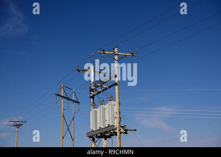 Hochspannungsleitungen und Transformatoren in einen blauen Himmel mit ...