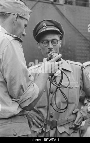 Aankomst M.S. Sloterdijk. Luitenant met microfoon. Saum staan voor een ...