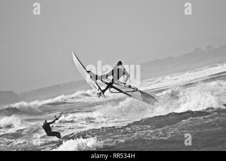 Ein Wind surfer wird Airborne auf dramatische White Water in grauen ...