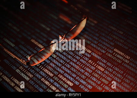 Hacker über einen Bildschirm mit Binärcode und Hacker-Warnmeldungen Stockfotografie - Alamy