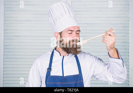 Probieren probieren. Einige Gewürze hinzufügen. Mann mit Bart in Cook ...