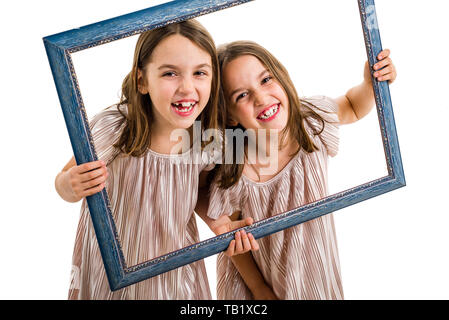 Identische Zwillinge Schwestern sind posieren für die Kamera. Happy Zwillingsschwestern in den ...