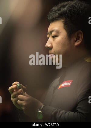 Li Hang of China chalks his cue as he considers a shot to Luca Brecel ...