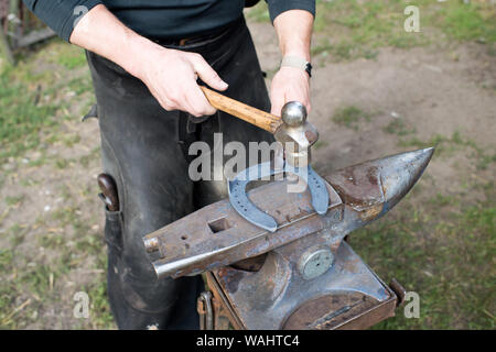 Schmied Arbeiten aus Metall mit einem Hammer auf dem Amboss in der ...