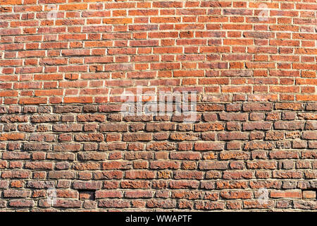 Sehr altes Mauerwerk aus rotem Backstein. Wand mit Gips abgefallen ...