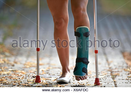 Junge Frau mit Fußverletzung, Sehnenruptur Achilles auf Krücken ...