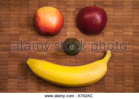 Lustige Obst Gesicht mit Banane, Gurke und Apfel auf Holztisch ...