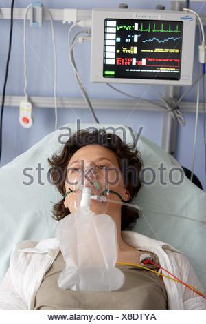 Patient mit Sauerstoff-Maske für die Unterstützung der Atmung bei ...