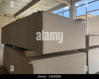 Les feuilles empilées de cloison sèche sur le chantier de construction ...