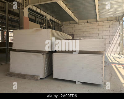 Les feuilles empilées de cloison sèche sur le chantier de construction ...