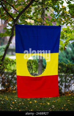 Détails avec le drapeau roumain avec un trou, le symbole de la ...