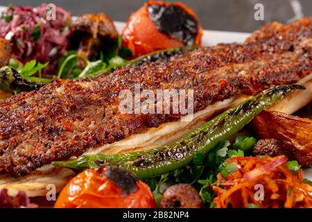 Adana kebab (viande hachée d'agneau hachée sur brochette sur le grill ...