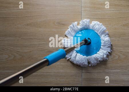 Un balai à franges rond avec tête en microfibre sur sol en carreaux de ...