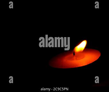 Un cierge allumé allumé dans le noir Photo Stock - Alamy
