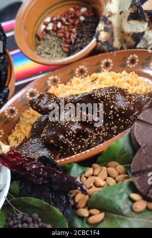 Poulet recouvert de sauce à la mole mexicaine, graines de sésame à côté ...