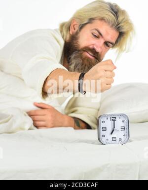 Il est temps de se réveiller. Homme épuisé réveillé par un réveil dans ...