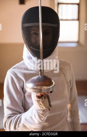 Portrait d'un tireur portant des uniformes d'escrime dans une salle de ...