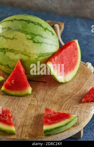 Mini pastèque avec des tranches de quartiers sur un support en bois sur ...