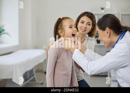Une jeune fille souriante ouvrant la bouche et montrant la longue ...
