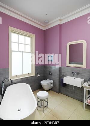 Baignoire rose à l'intérieur d'une salle de bains résidentielle avec ...