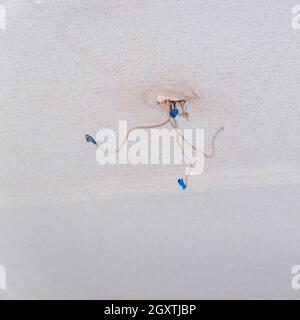 Câblage dangereux et défectueux suspendu au plafond depuis une vieille ...