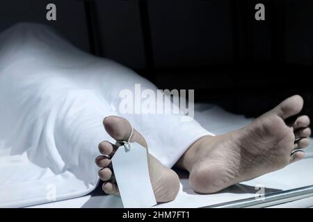 Cadavre humain recouvert d'une feuille et d'une étiquette nomintive sur ...