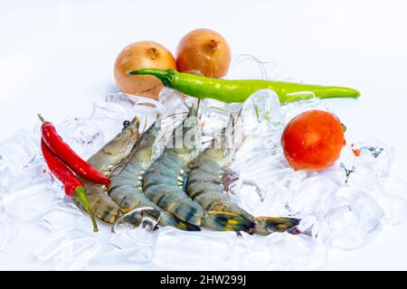 Fruits de mer sur glace écrasée et surface sombre. Crevettes crues ...