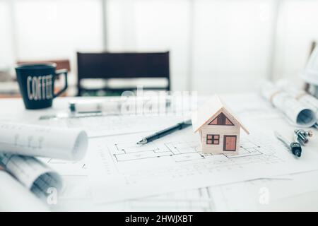 Mini modèle maison, crayon, boussole et plan de rouleau sur plan de ...